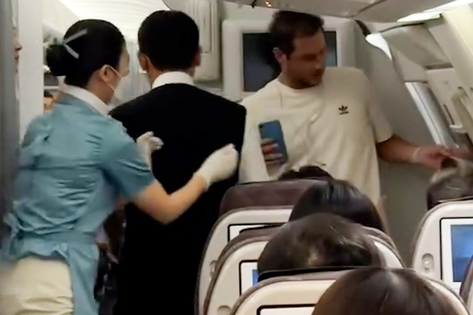 Wild scene in mid flight as passenger is restrained after apparent ...